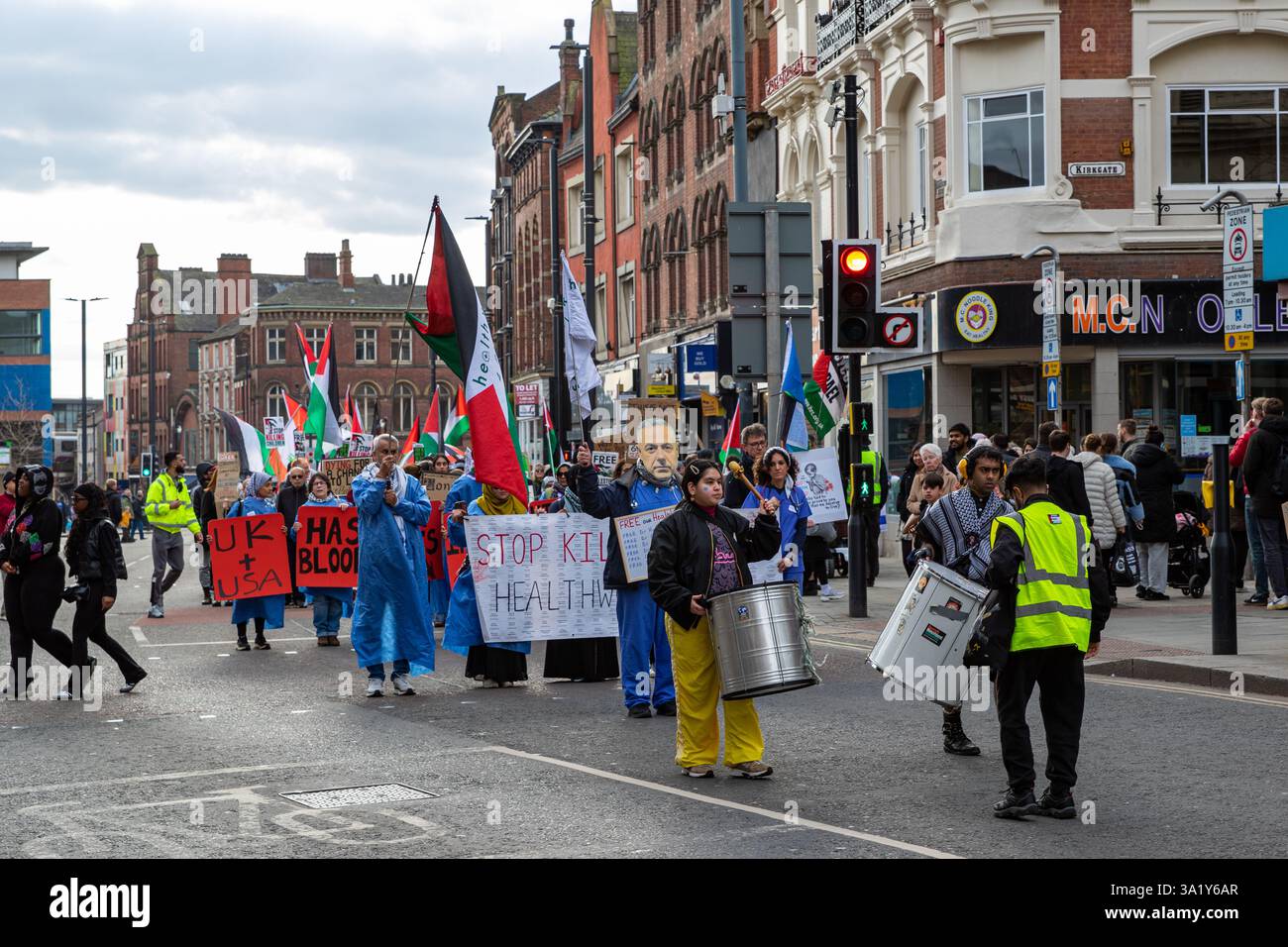 A street level view of a protest march in a city street with protestors ...