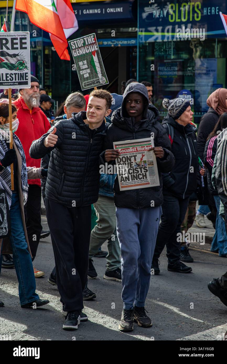 A street-level shot shows a crowd of protestors with signs, including ...