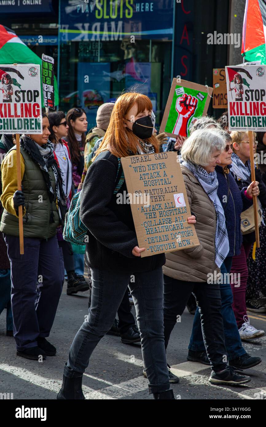 A diverse group marches in a protest, holding signs with messages ...