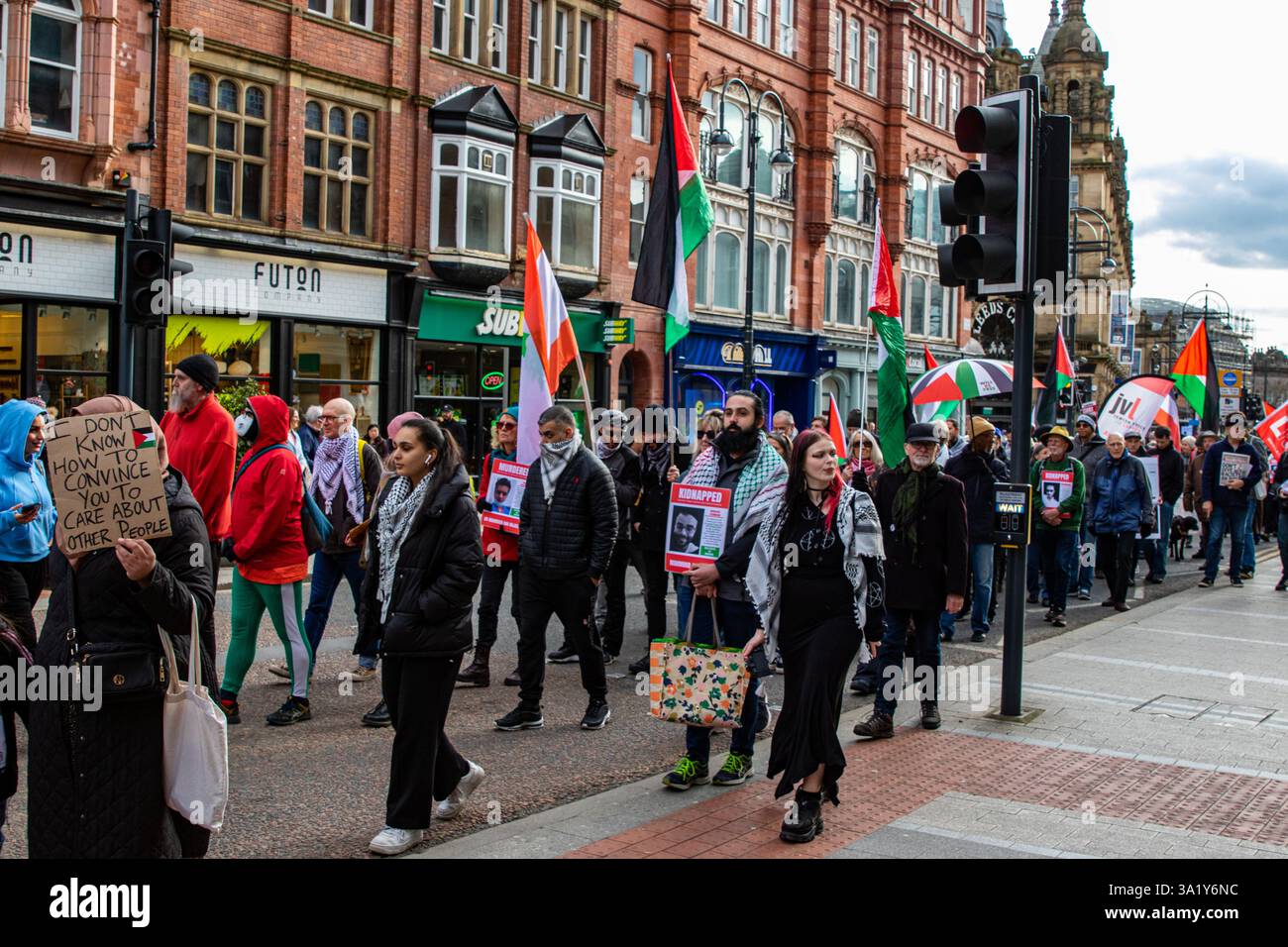 Street-level view of a group marching in a city; individuals holding ...