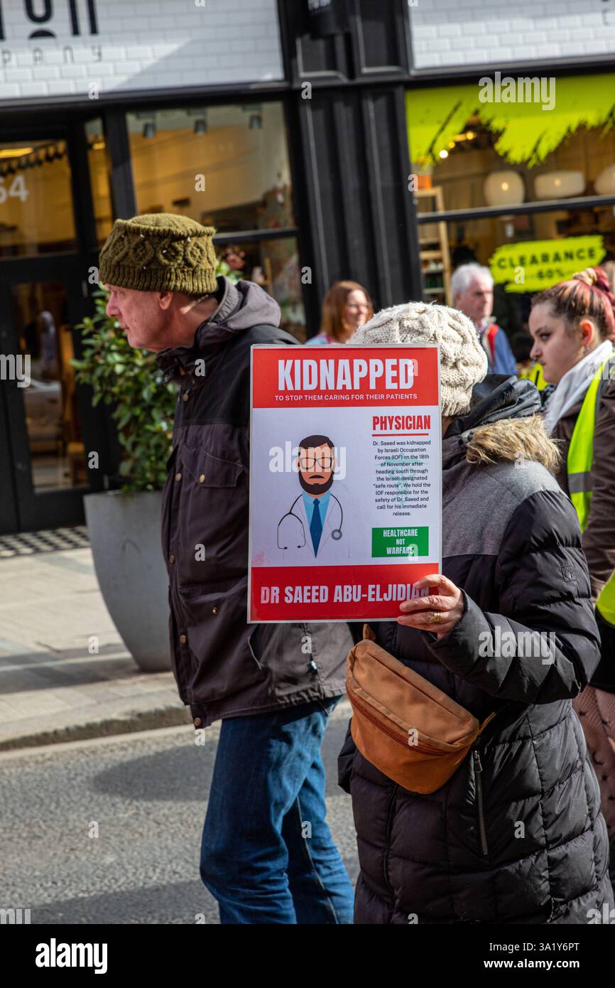 Two people are seen at a protest carrying a sign about Dr. Saeed Abu ...