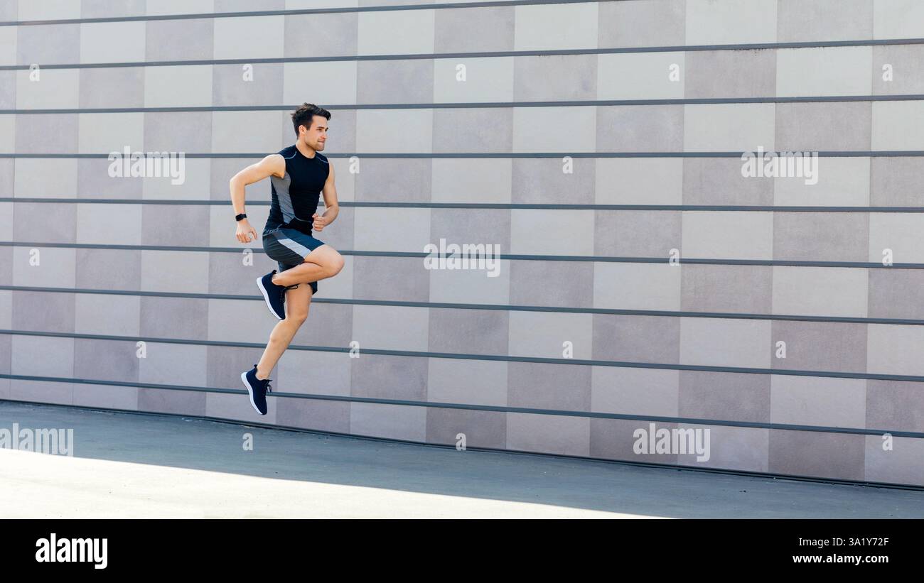 Freeze in air at training. Slender guy jumping and running on street ...