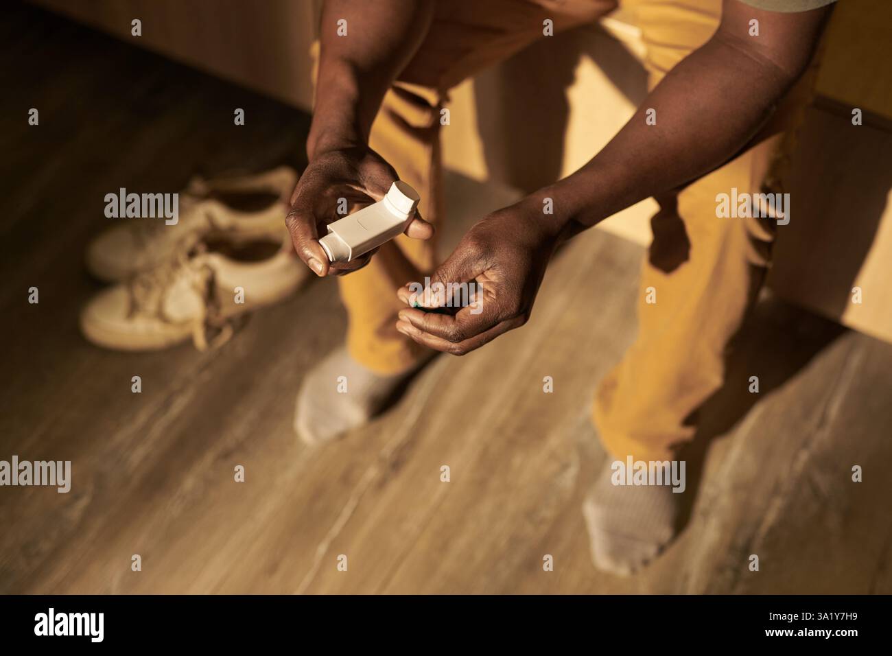 High angle of hands of African American senior man holding inhaler ...