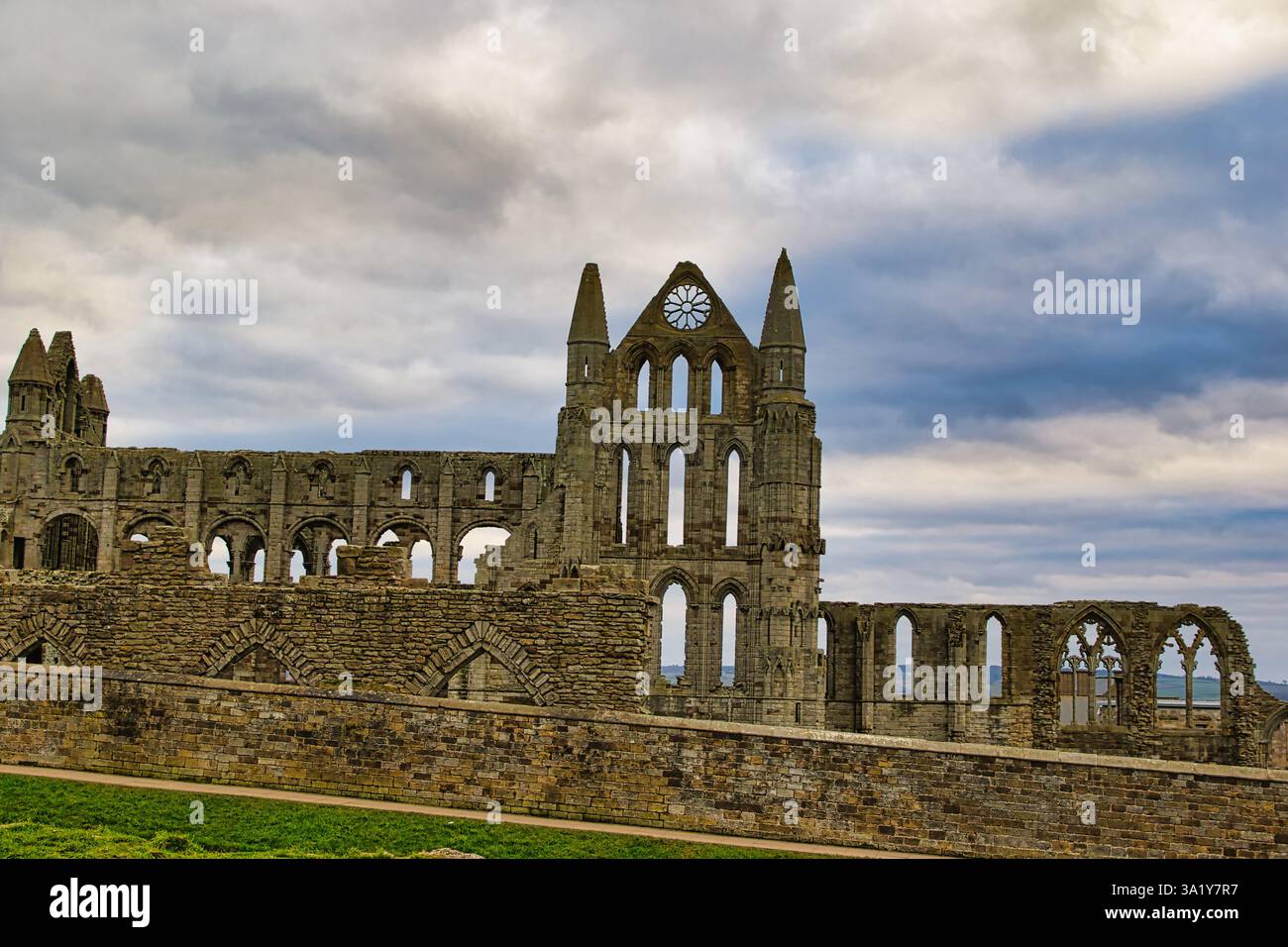 Whitby Abbey ruins stand against a cloudy sky, featuring stone walls ...