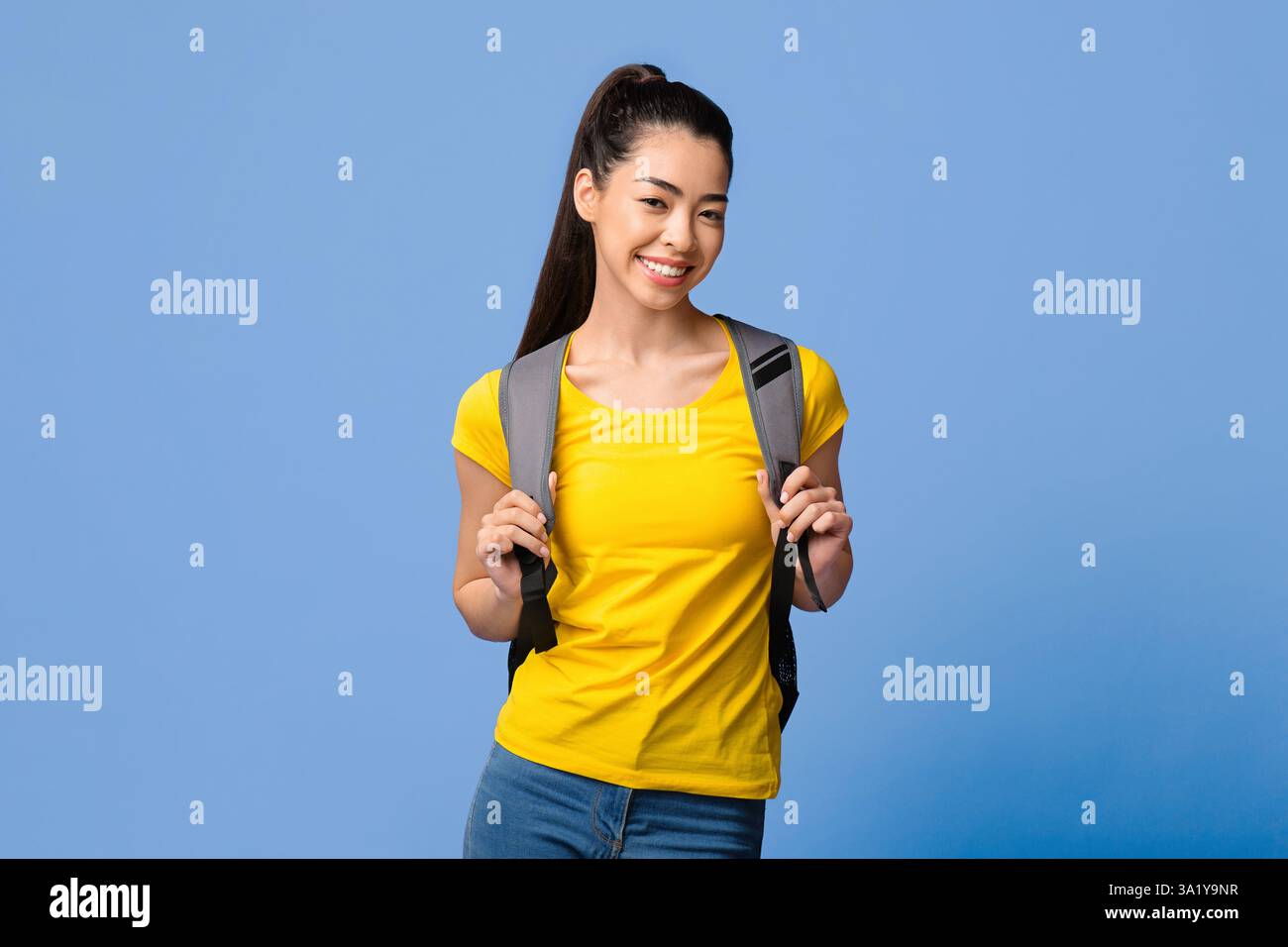 Young Beautiful Asian Female Student With Backpack Posing Over Purple ...