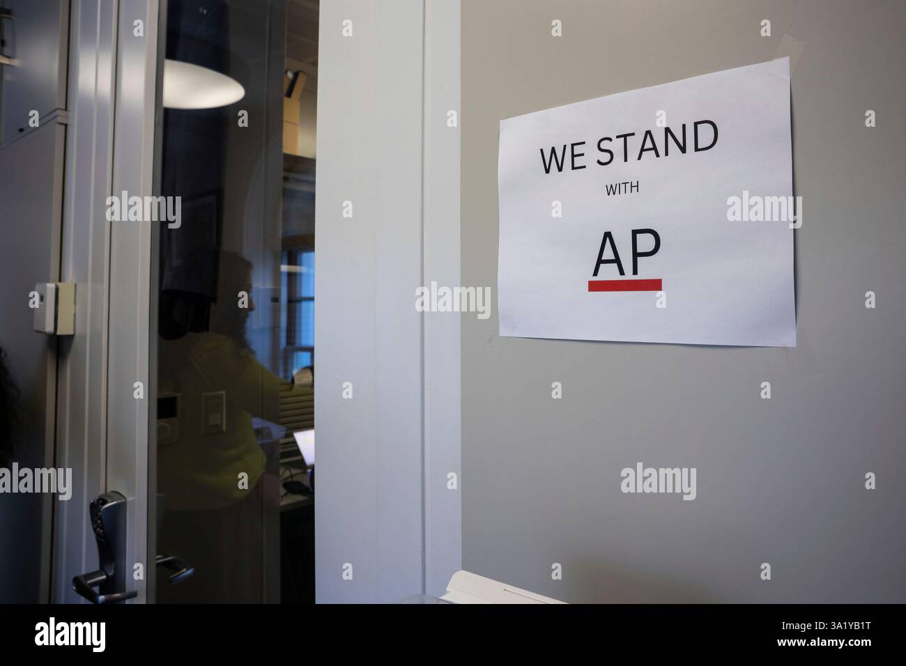 A sign that says "WE STAND WITH AP" is seen in the press area of the ...