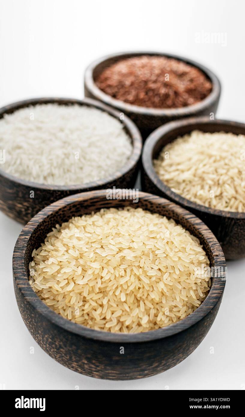 different kinds of asian rice grains in bowls on white background in ...