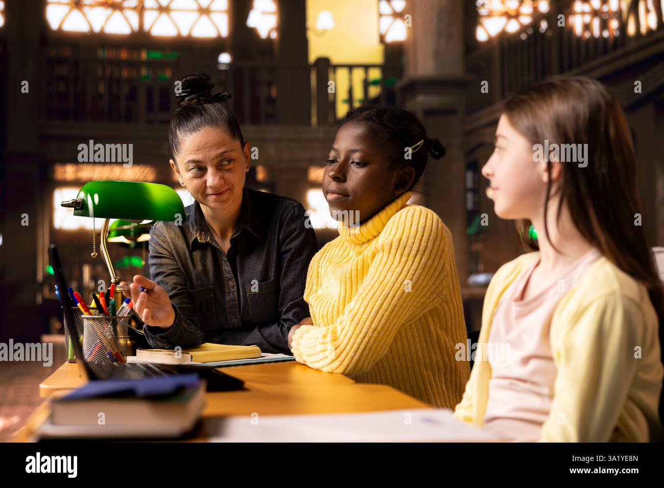 Elementary school professor engaging with girls students during private ...