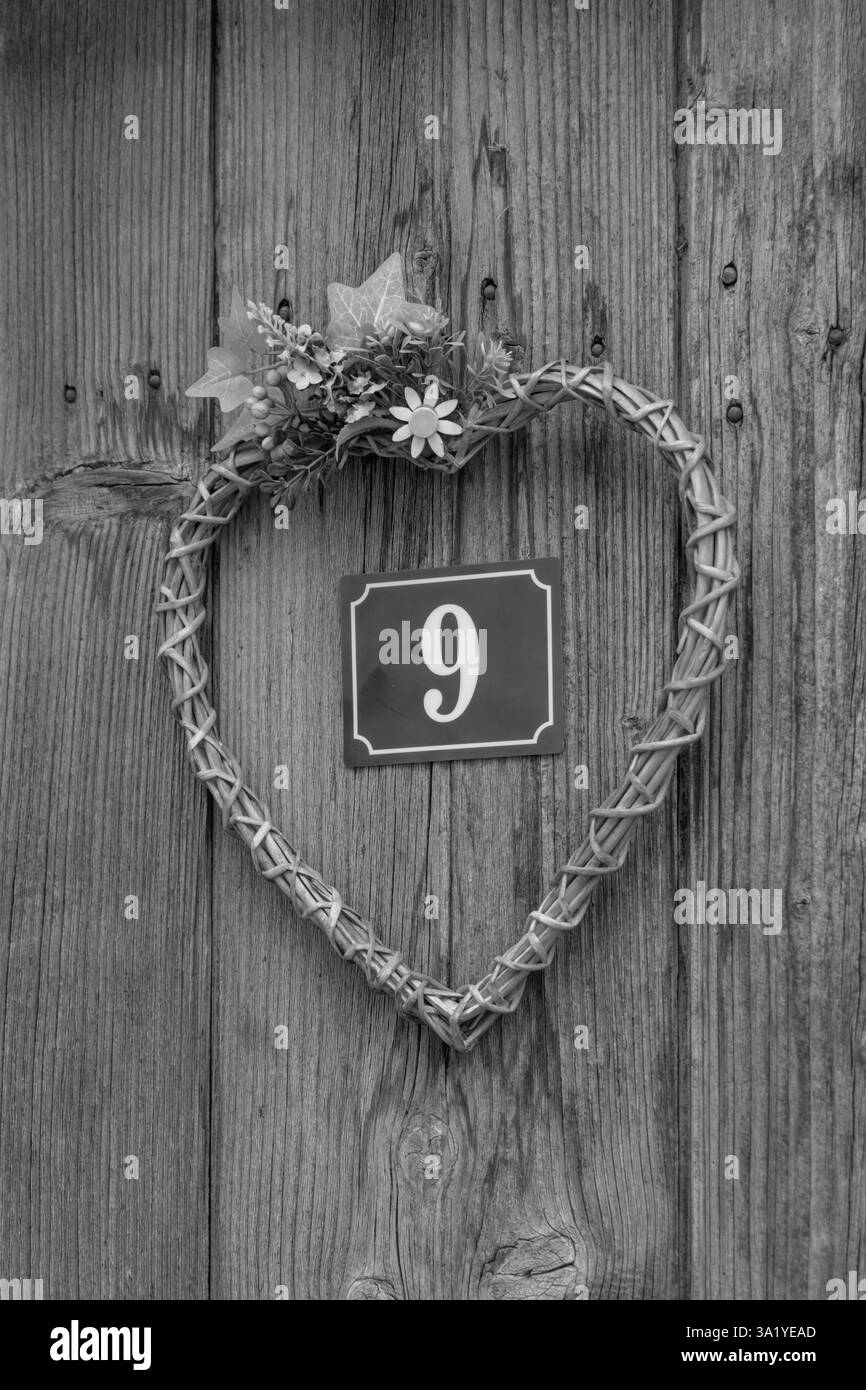 House number 9 (nine) on wood wall with heart shape frame in black and ...