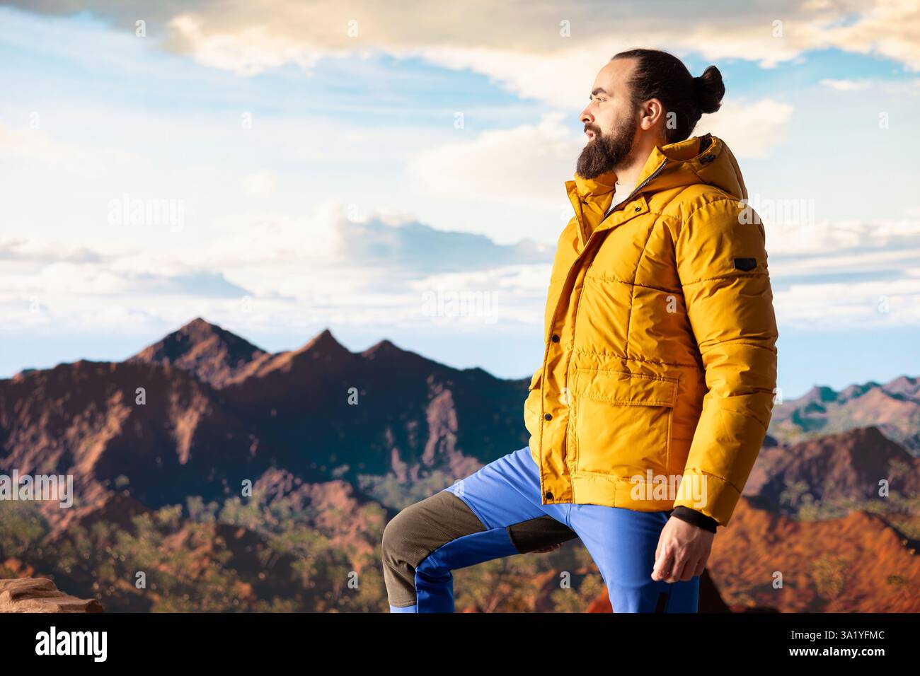 Determined traveler enjoys the solitude of a mountain summit, where the ...