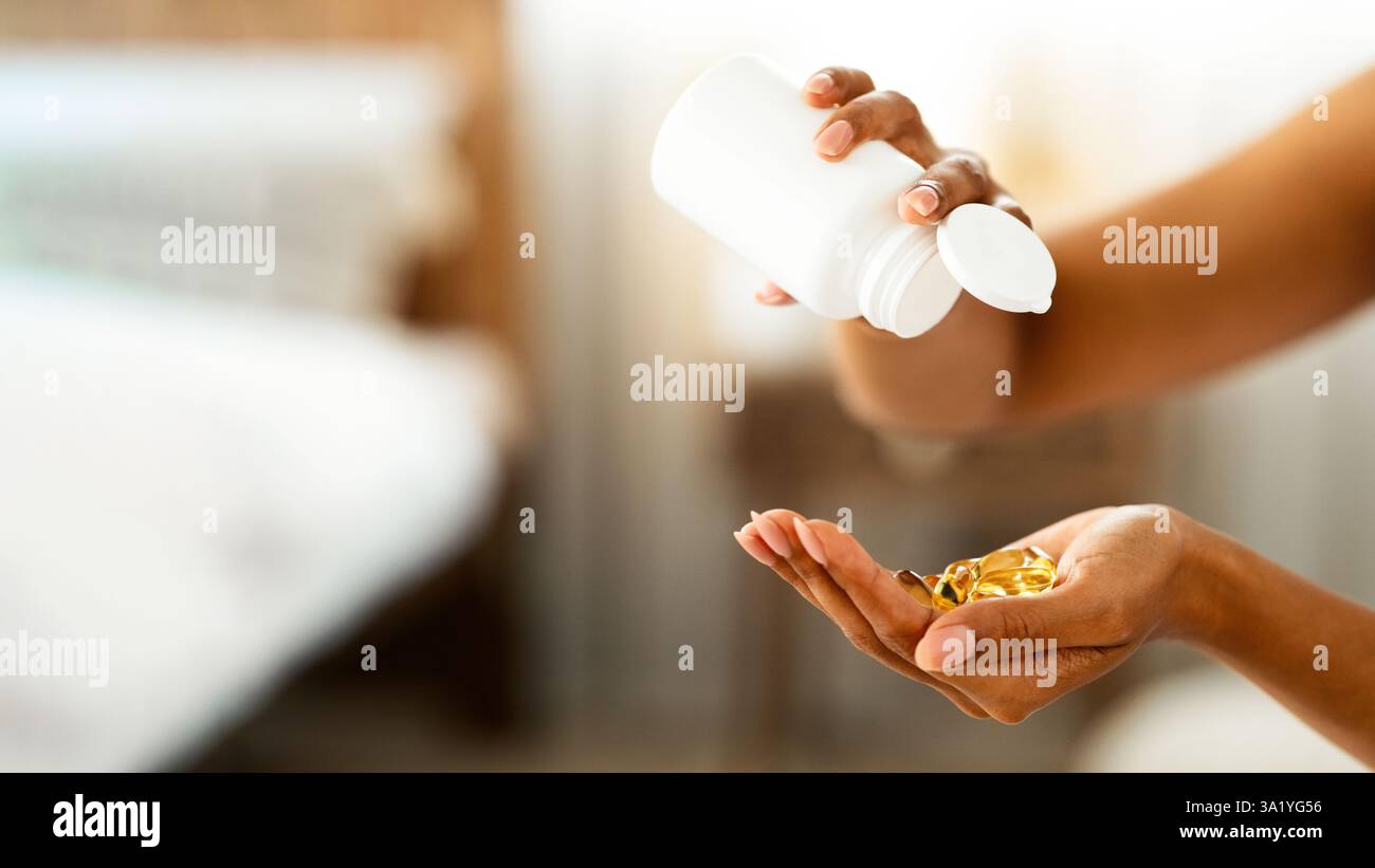 Black woman pouring capsules hi-res stock photography and images - Alamy