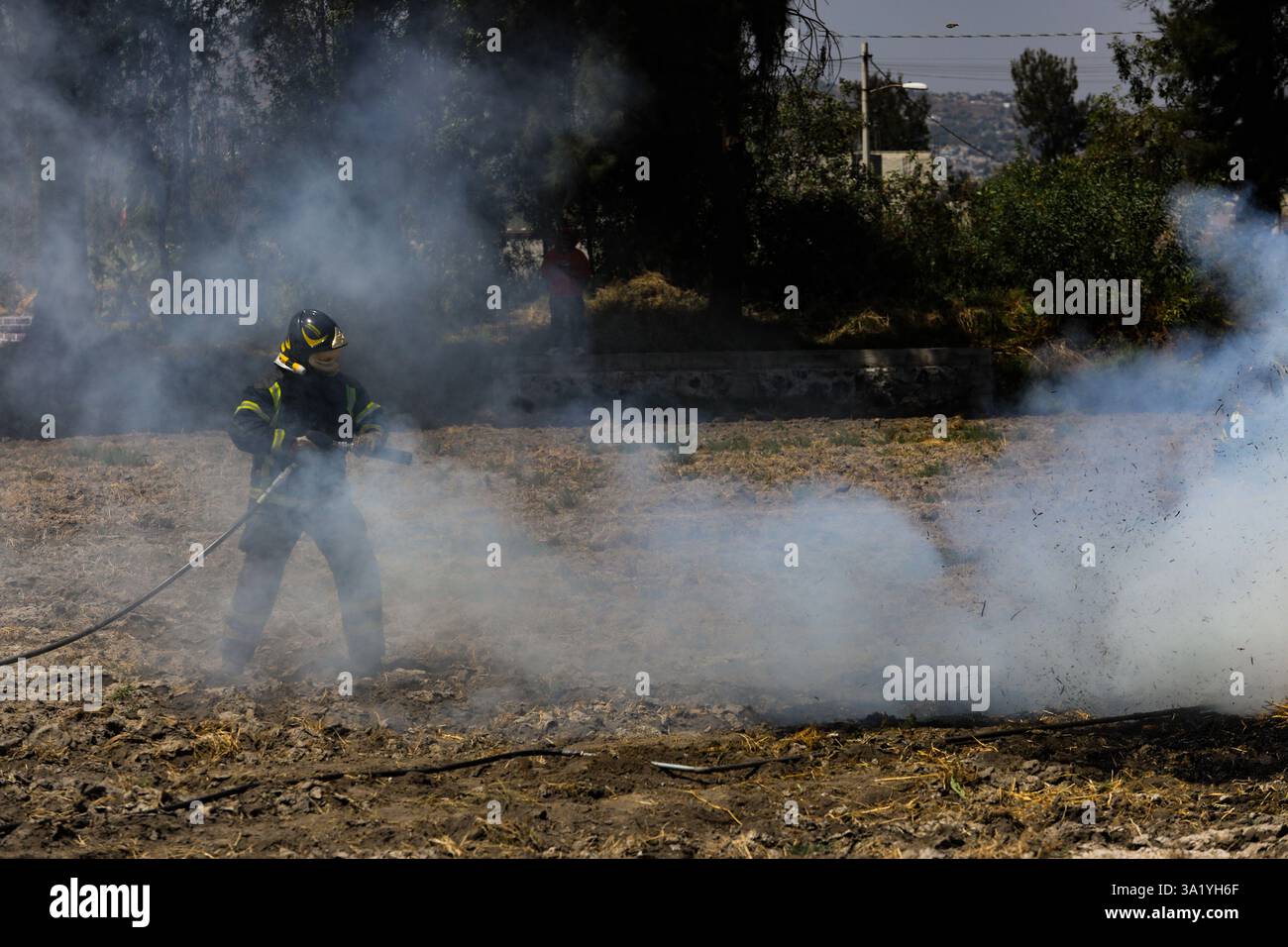A member of the Mexico City Fire Department extinguishes a fire during ...