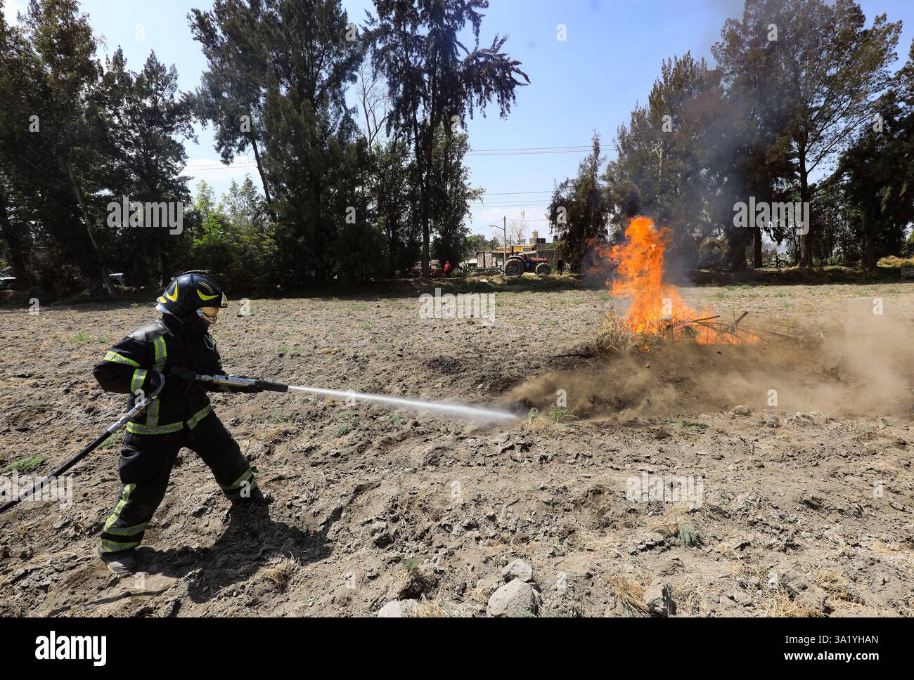 A member of the Mexico City Fire Department extinguishes a fire during ...