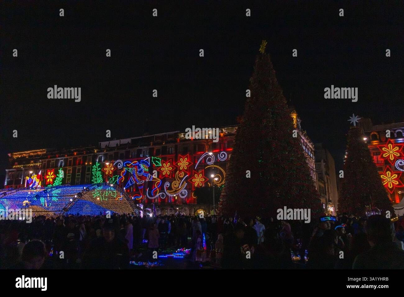 Bight scene featuring illuminated buildings, Christmas trees, a glowing ...