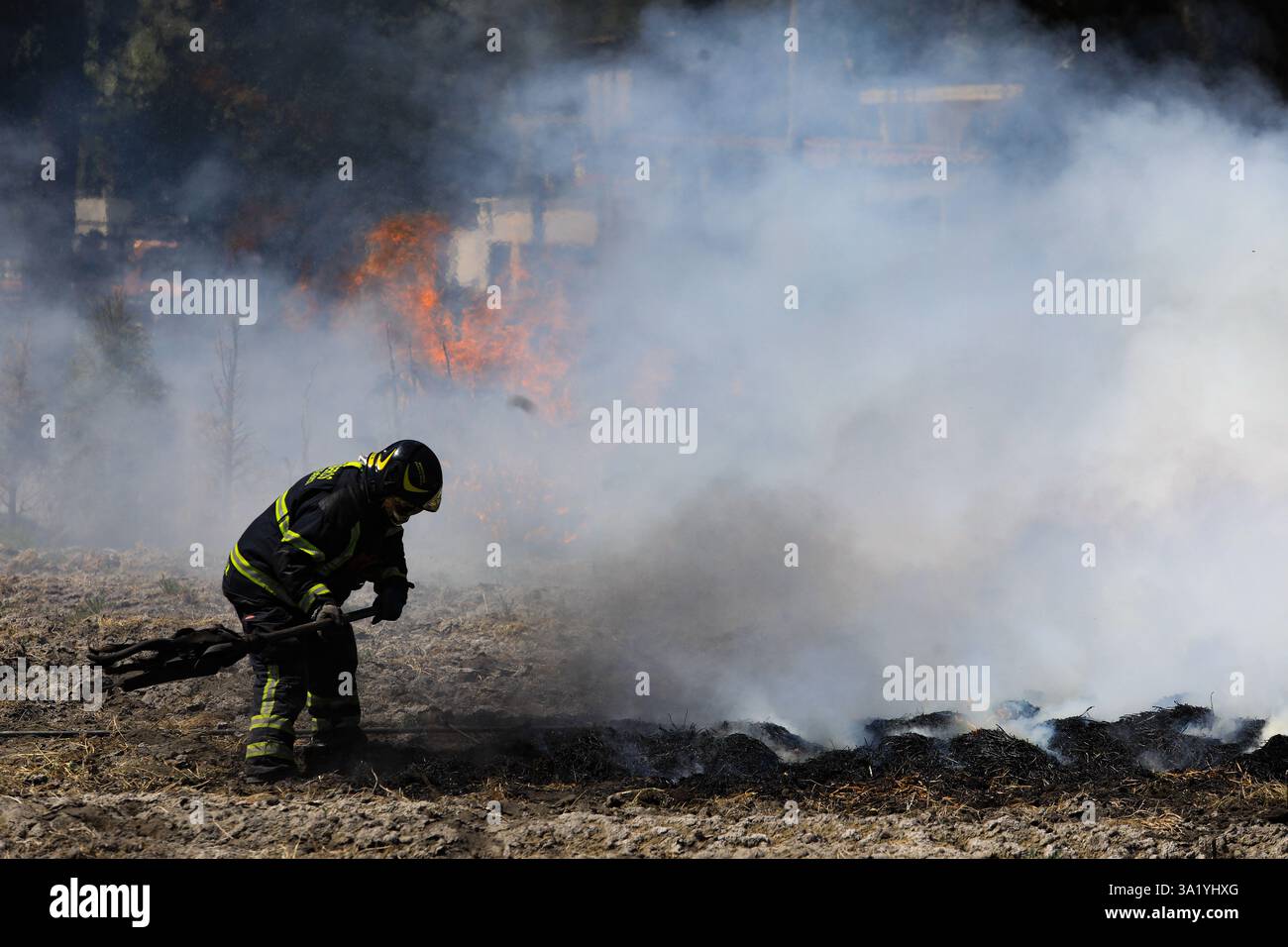 A member of the Mexico City Fire Department extinguishes a fire during ...