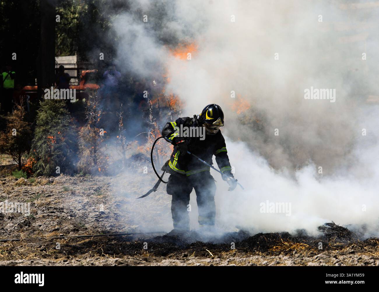 A member of the Mexico City Fire Department extinguishes a fire during ...