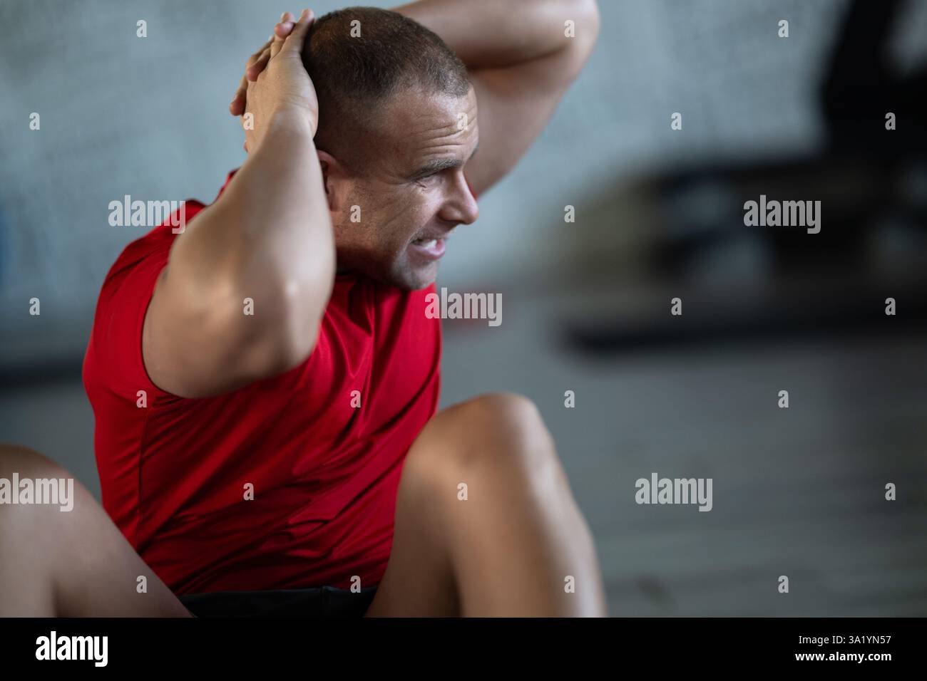A muscular man performing crunches in the gym, focusing on building ...