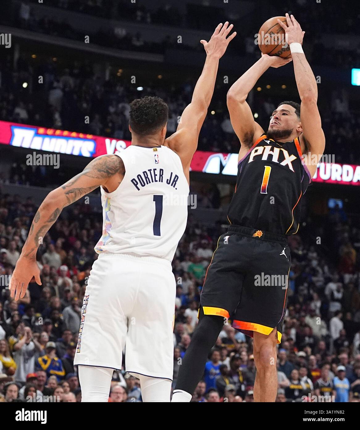 Phoenix Suns guard Devin Booker (1) shoots over Denver Nuggets forward ...
