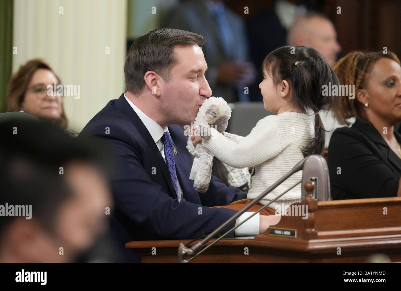 Democratic Assemblymember Patrick Ahrens kisses a stuffed lamb ...