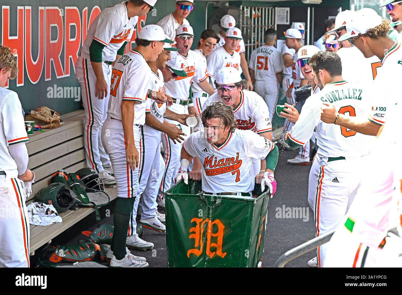 CORAL GABLES, FL - MARCH 09: Miami's team pushes outfielder Max Galvin ...