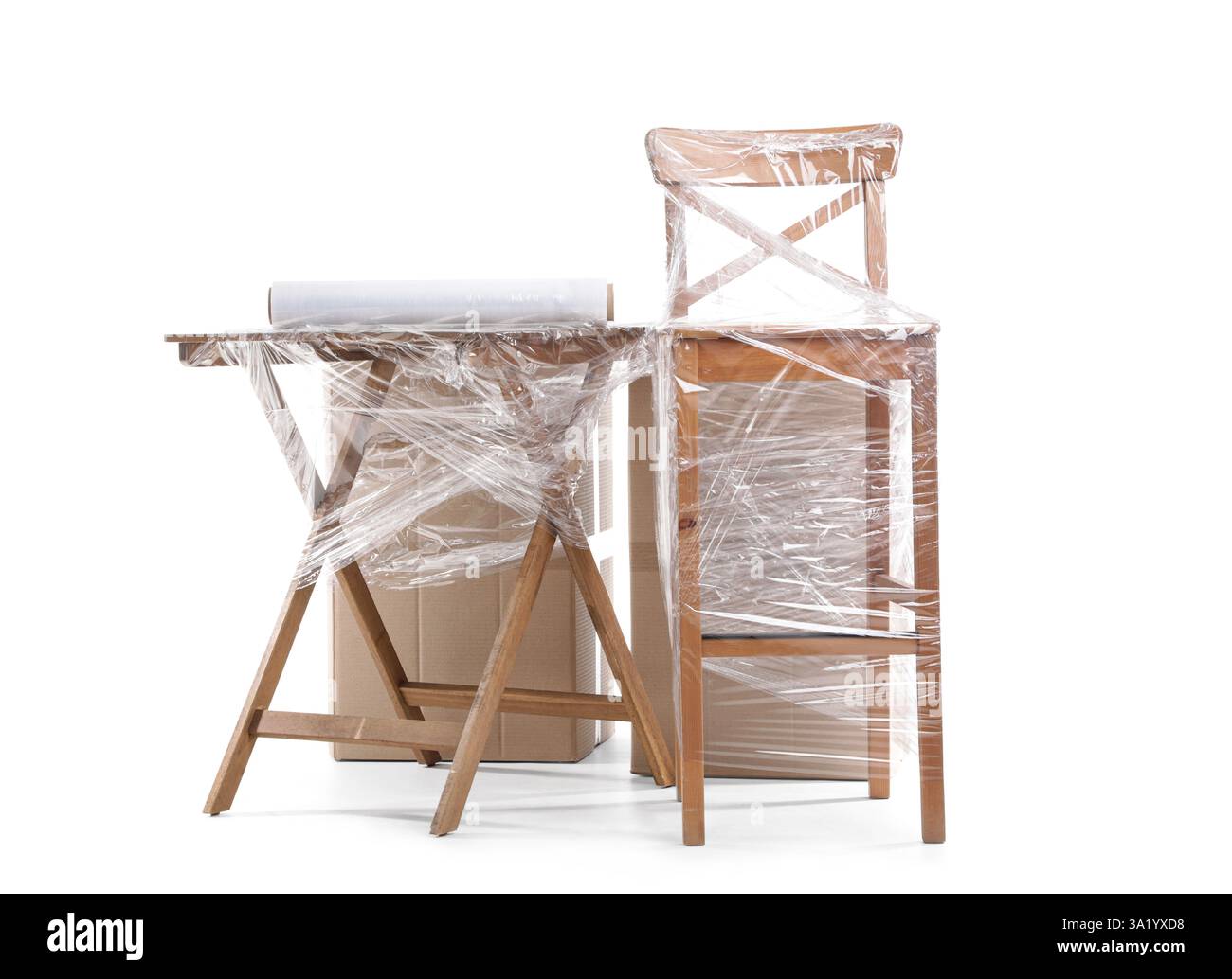 Table with chair wrapped in stretch film and moving boxes on white ...