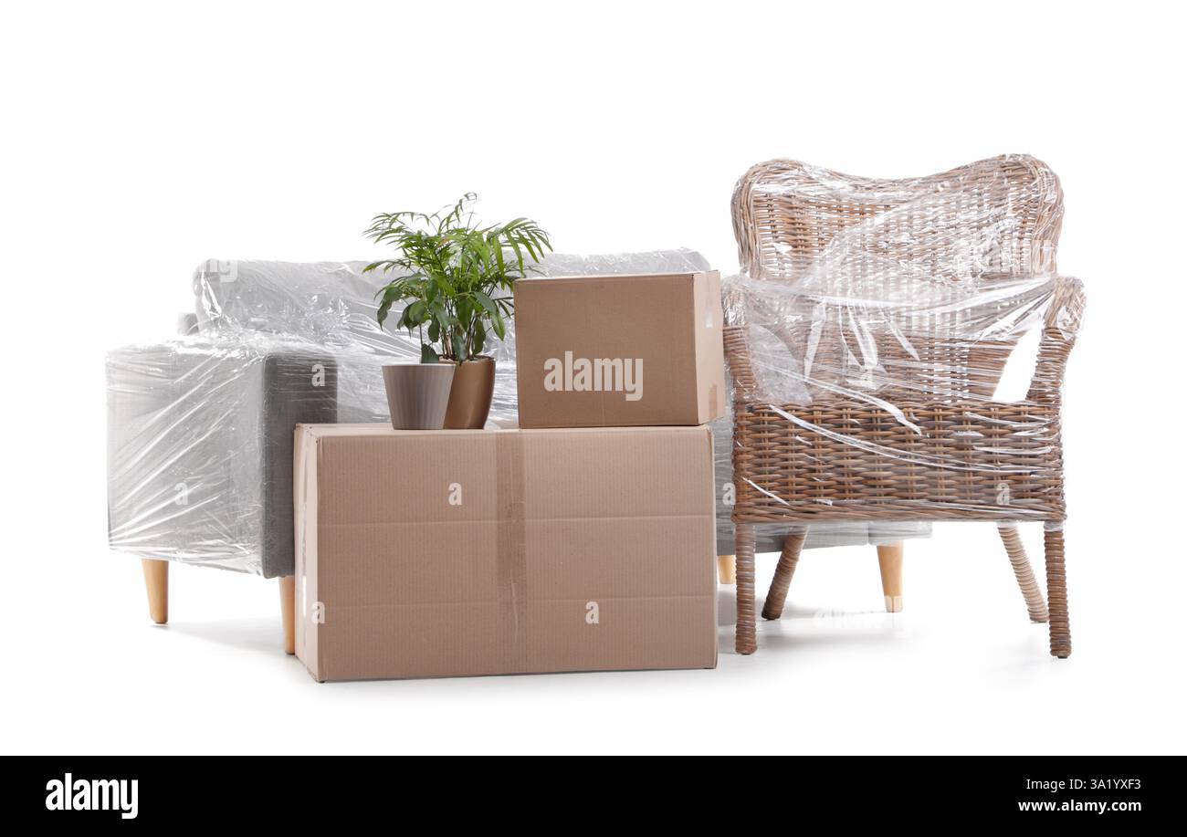 Sofa and armchair wrapped in stretch film with moving boxes on white ...