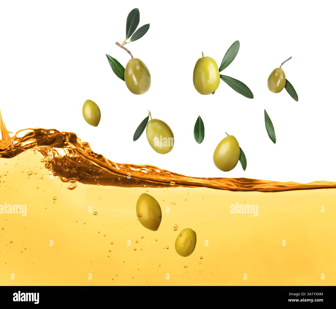 Green olives and leaves falling into cooking oil on white background ...