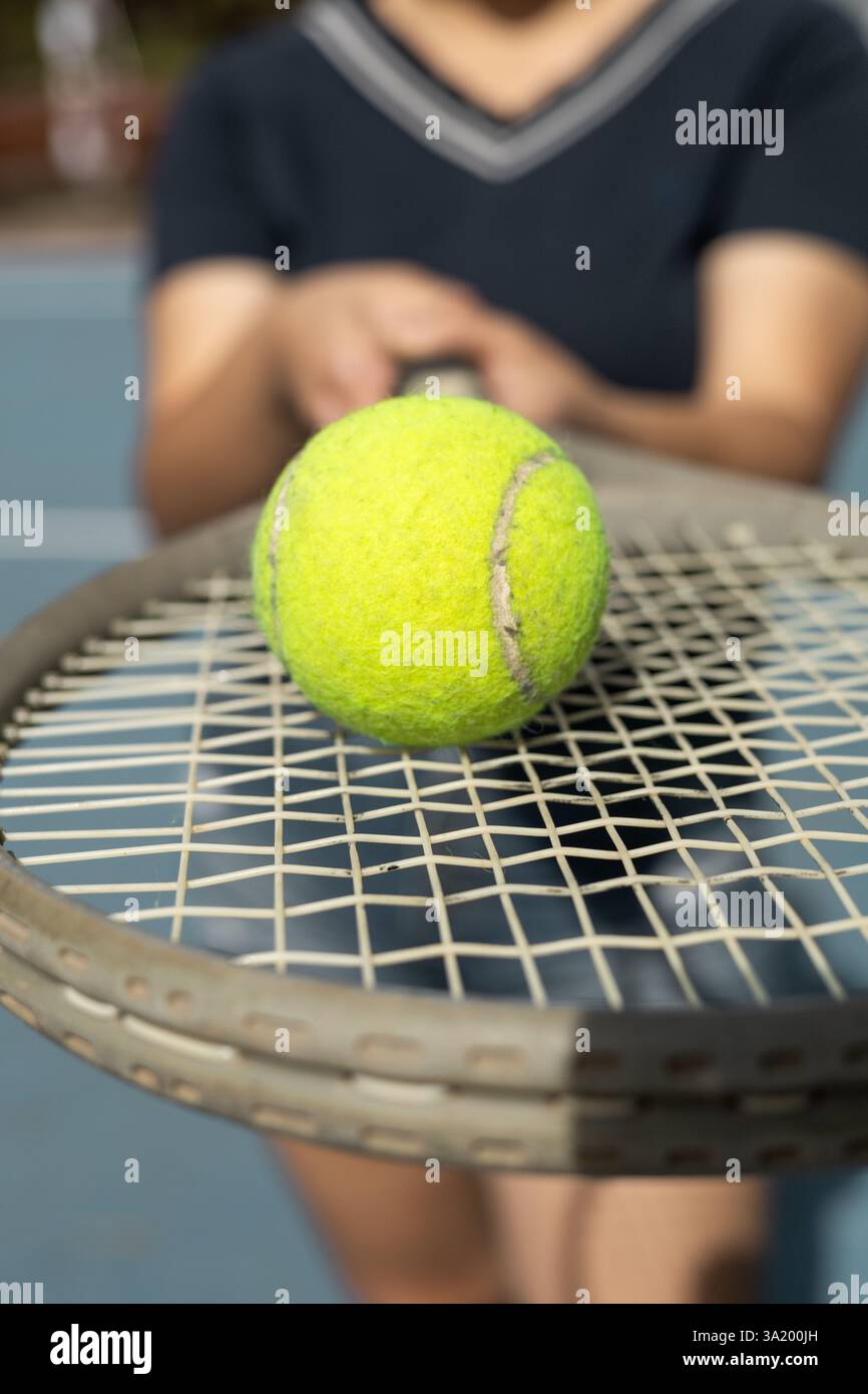 A close-up shot of a girl holding a tennis racket with a tennis ball ...