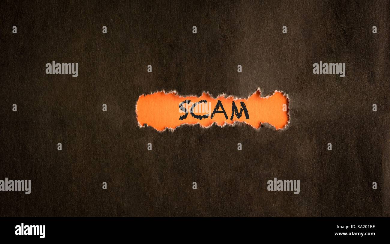 SCAM word on orange background with torn black paper Stock Photo - Alamy