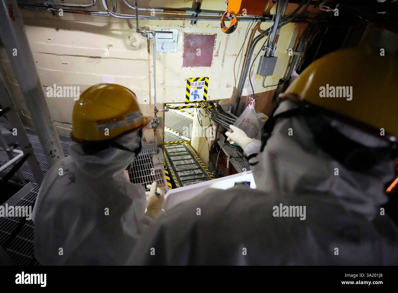 Employees of Tokyo Electric Power Company Holdings (TEPCO) take AP journalists to the area under ...