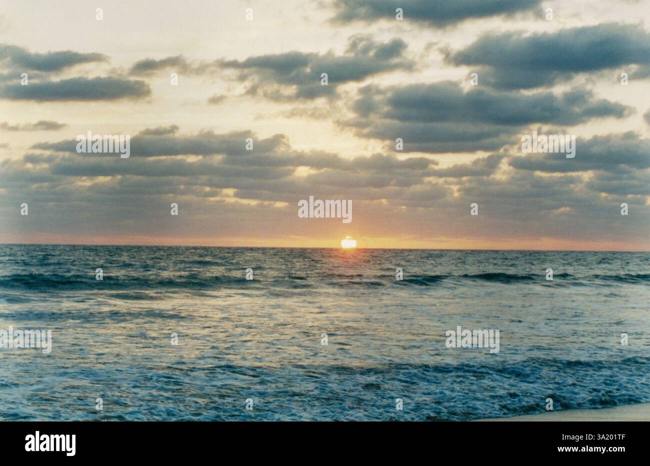 Analogue image of the sun setting over the horizon in the Pacific Sea ...
