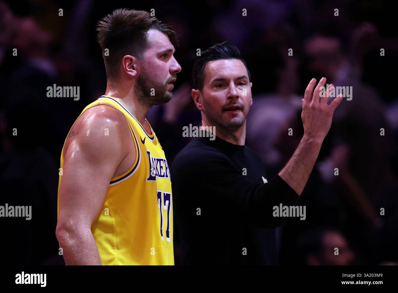 Los Angeles Lakers' Luka Doncic, left, talks with head coach JJ Redick, right, during the first ...