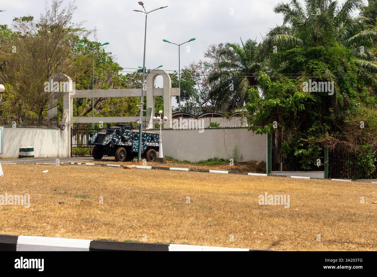 An armored police vehicle parked near a gated entrance surrounded by ...