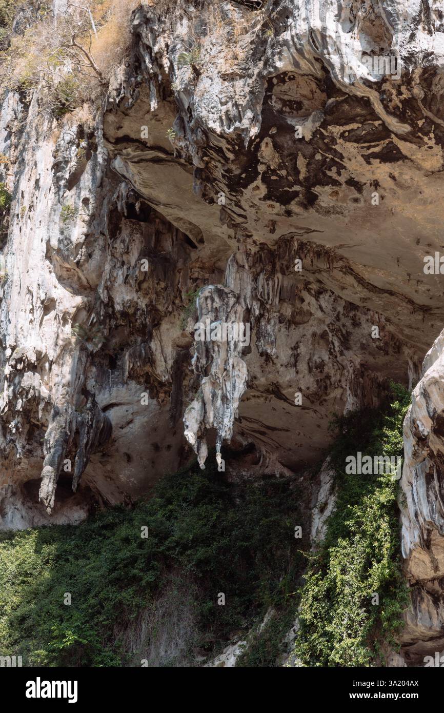 Unique rock formations hang from the ceiling of a natural cave while ...
