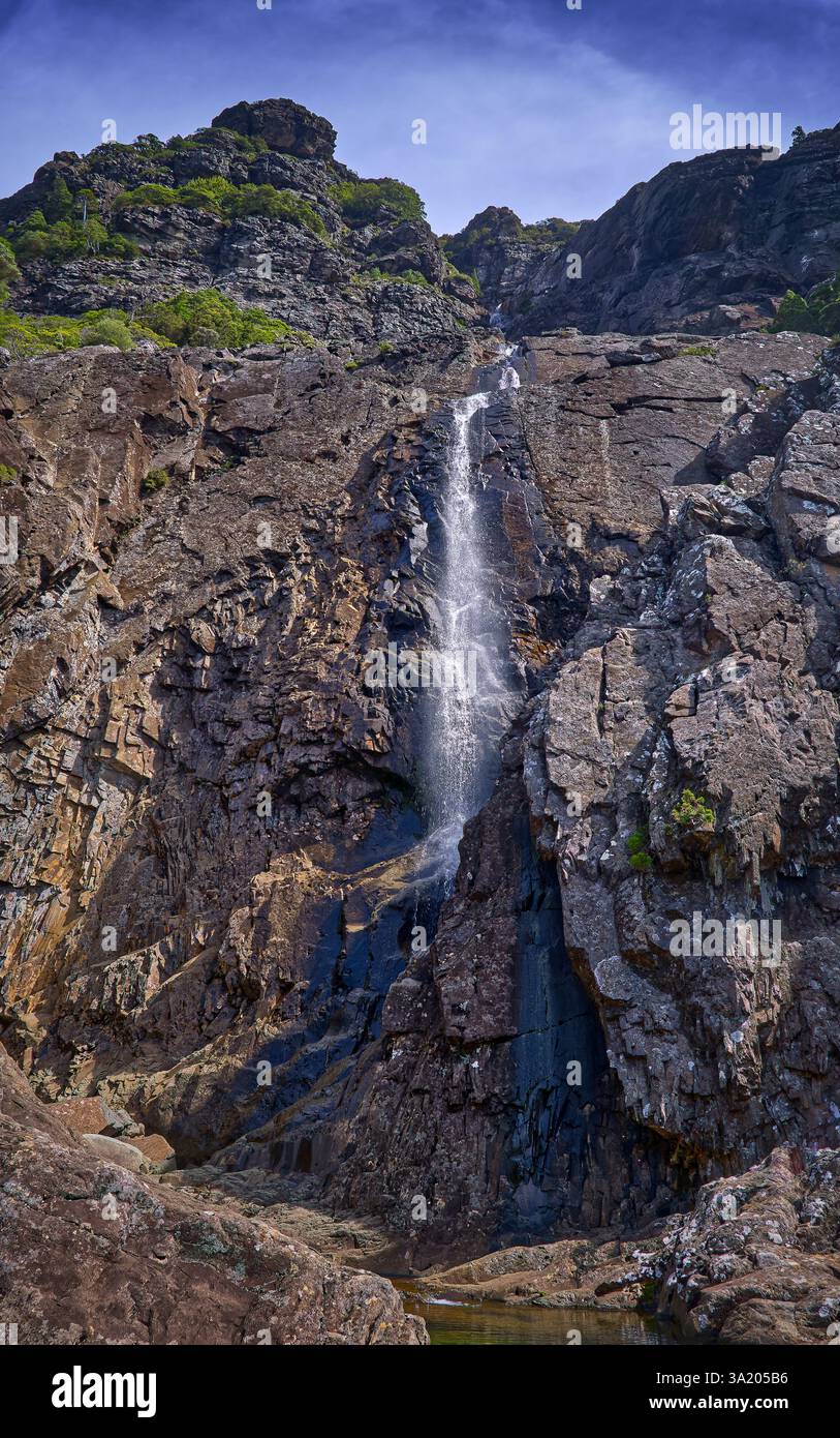 Portrait image of Meander falls cascading over rocky dolerite cliff ...