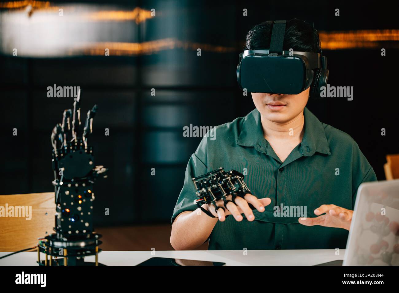 Asian teenager experiments with a robot arm project using VR glasses in ...