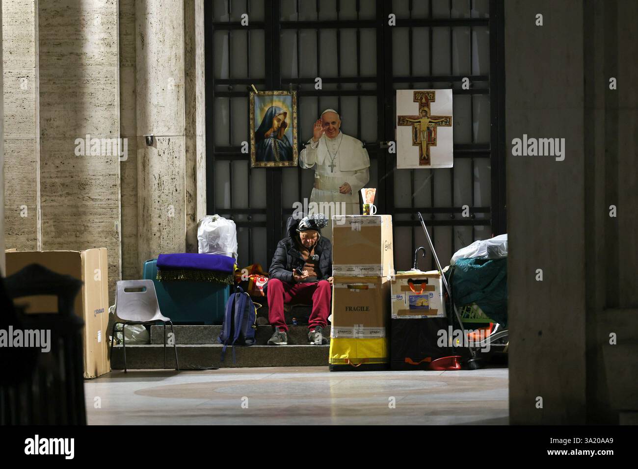 Vatican City, Italy. 08th Mar, 2025. Homeless man looks at cell phone ...