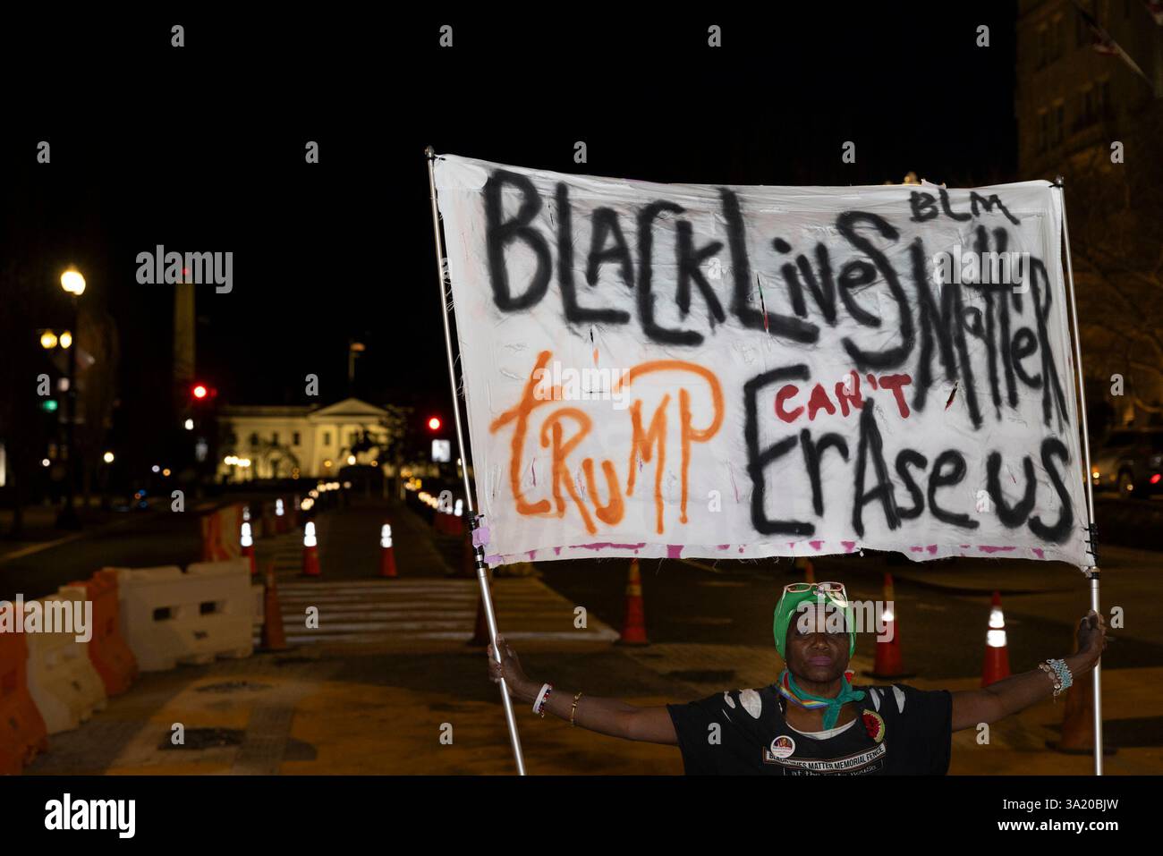 A demonstrator holds a sign after local government crews begin work to ...