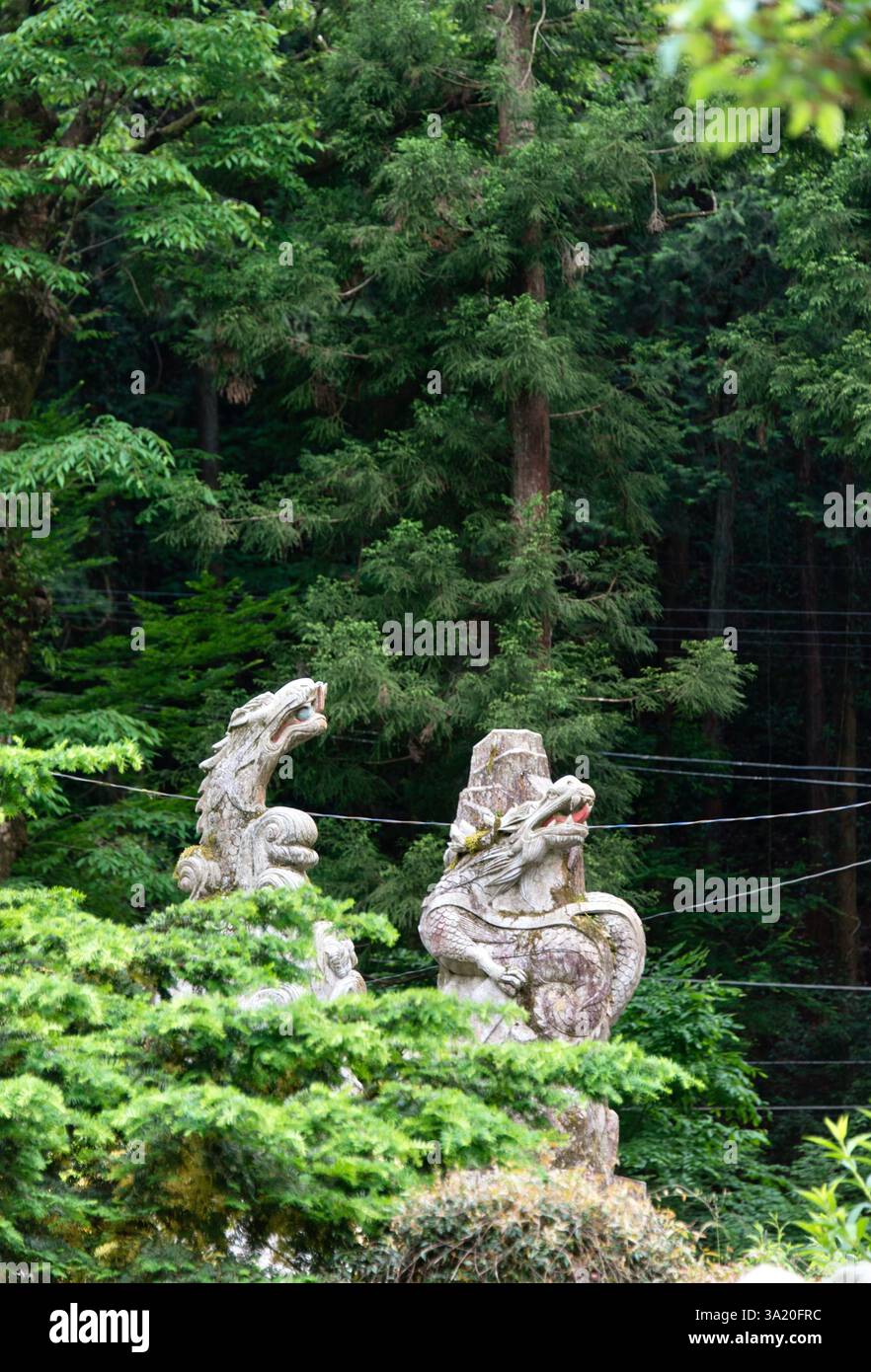Statues marshall the entrance gates to Yozawa Shrine, which stands near ...