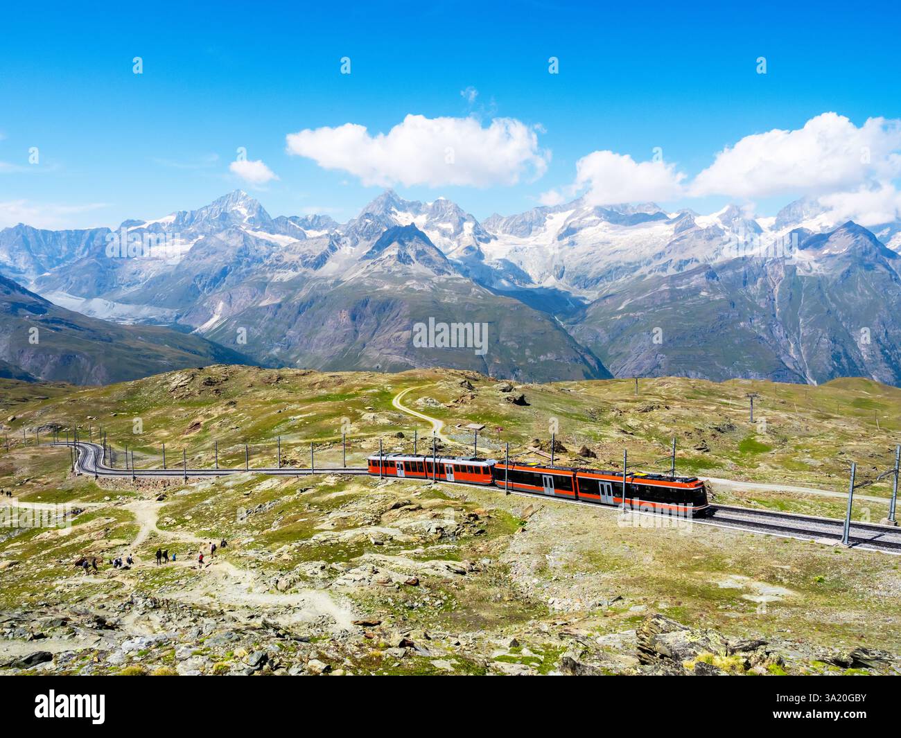 Red tourist train on Gornergrat railway, going up the hill, on complex ...