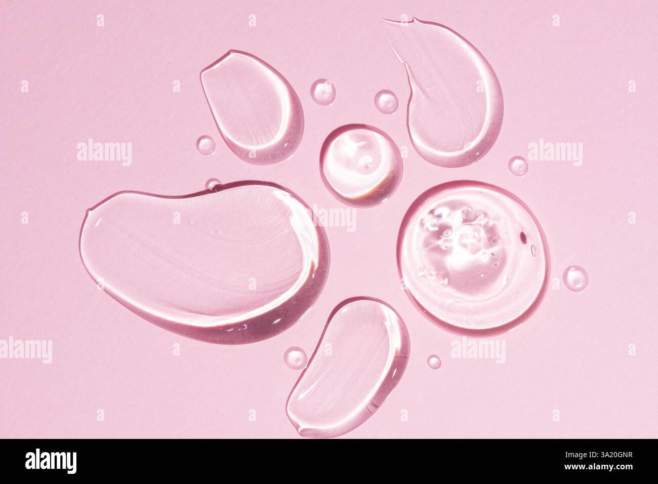 Pure transparent cosmetic gel drops and smears on pink background, skin ...