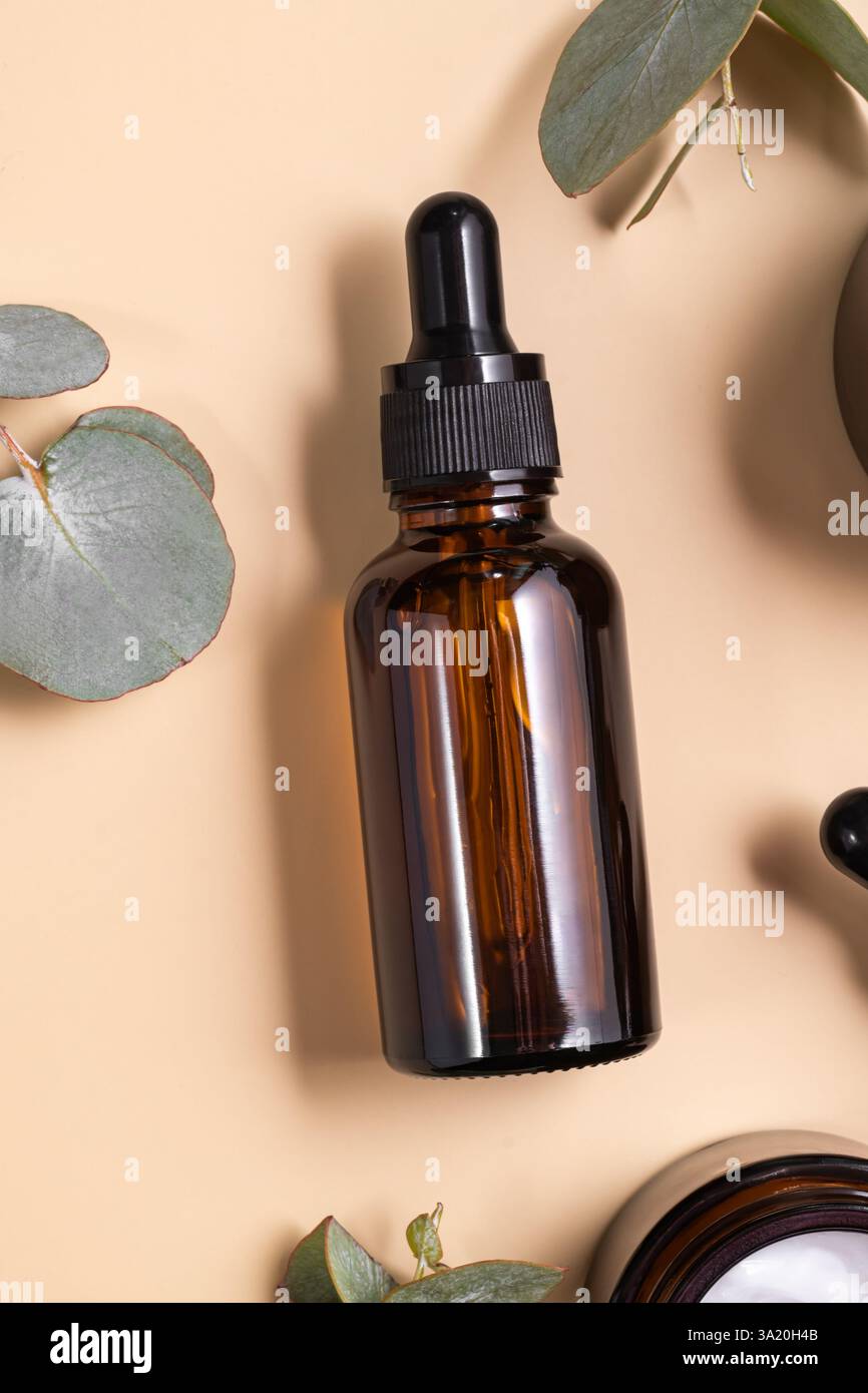 Blank amber glass essential oil bottle with pipette on beige background ...
