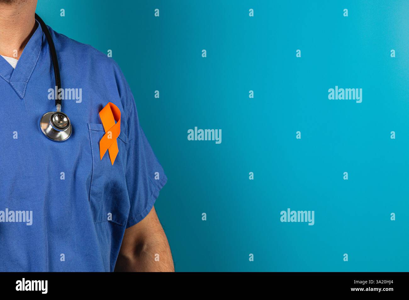 A medical professional in blue scrubs stands against a turquoise ...