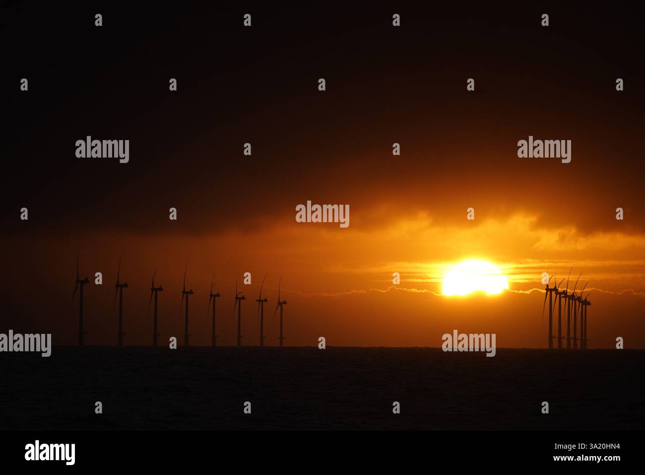 Sunrise behind a windfarm near Easington beach, Hull, after a crash ...