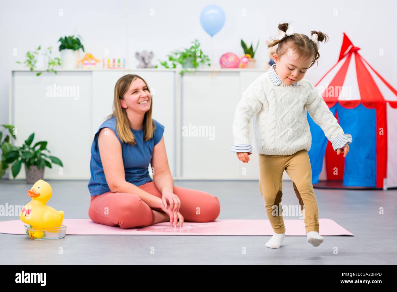 Toddler girl with Down syndrome in child occupational therapy session ...