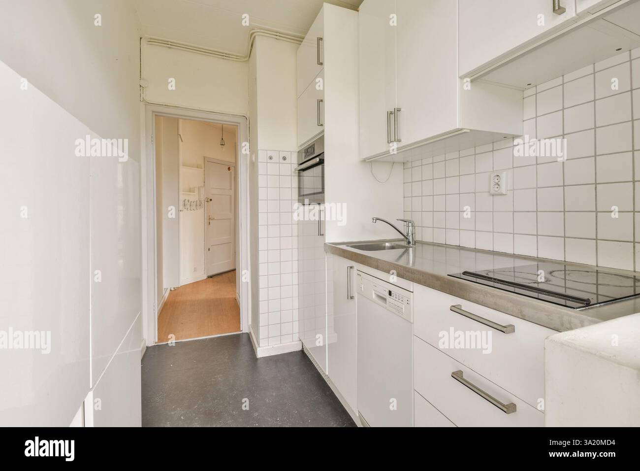 A sleek and modern kitchen featuring white cabinets, minimalist ...