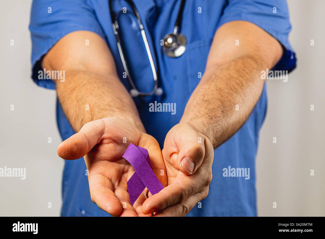 A healthcare worker extends both hands forward, displaying a purple ...