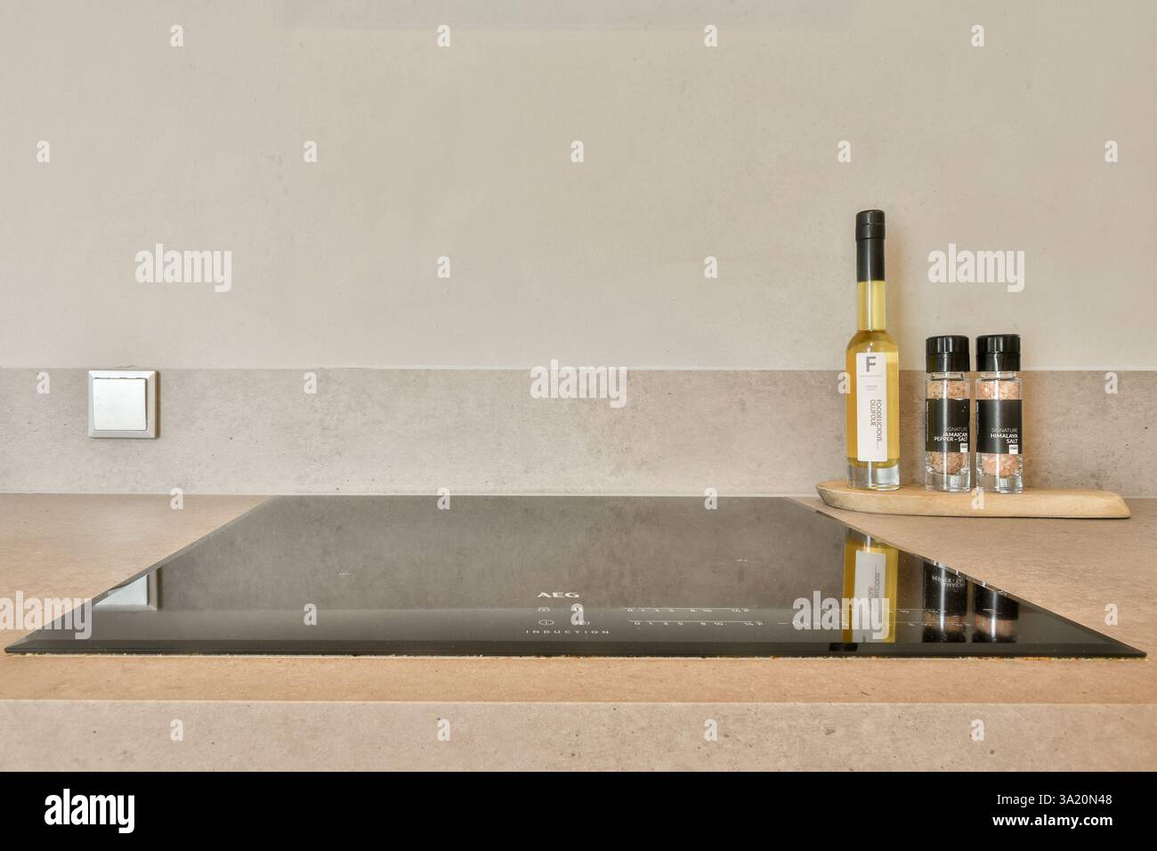 A sleek, contemporary kitchen setup featuring a black cooking surface ...