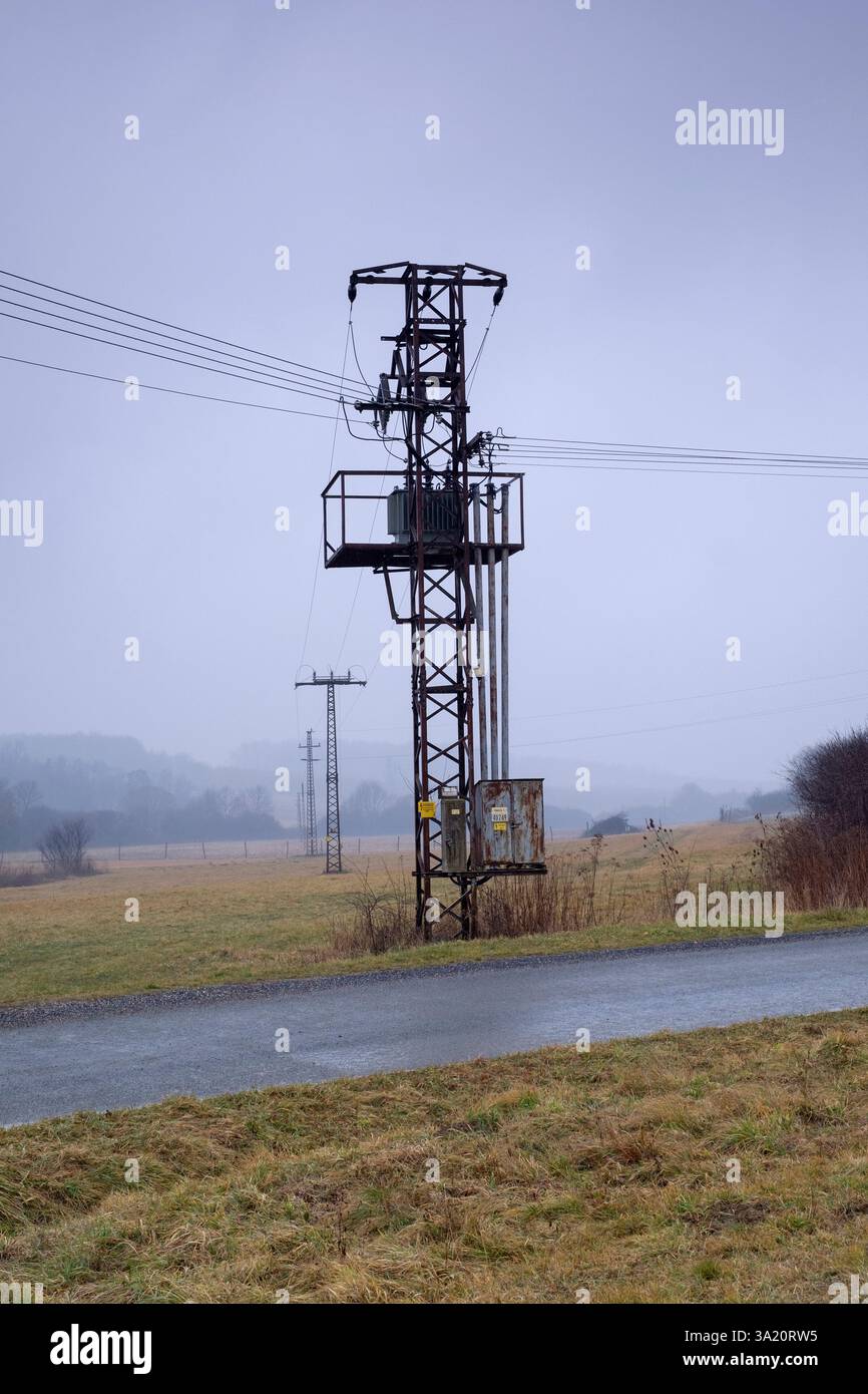 rural countryside pylons carrying electricity cables fade into the ...