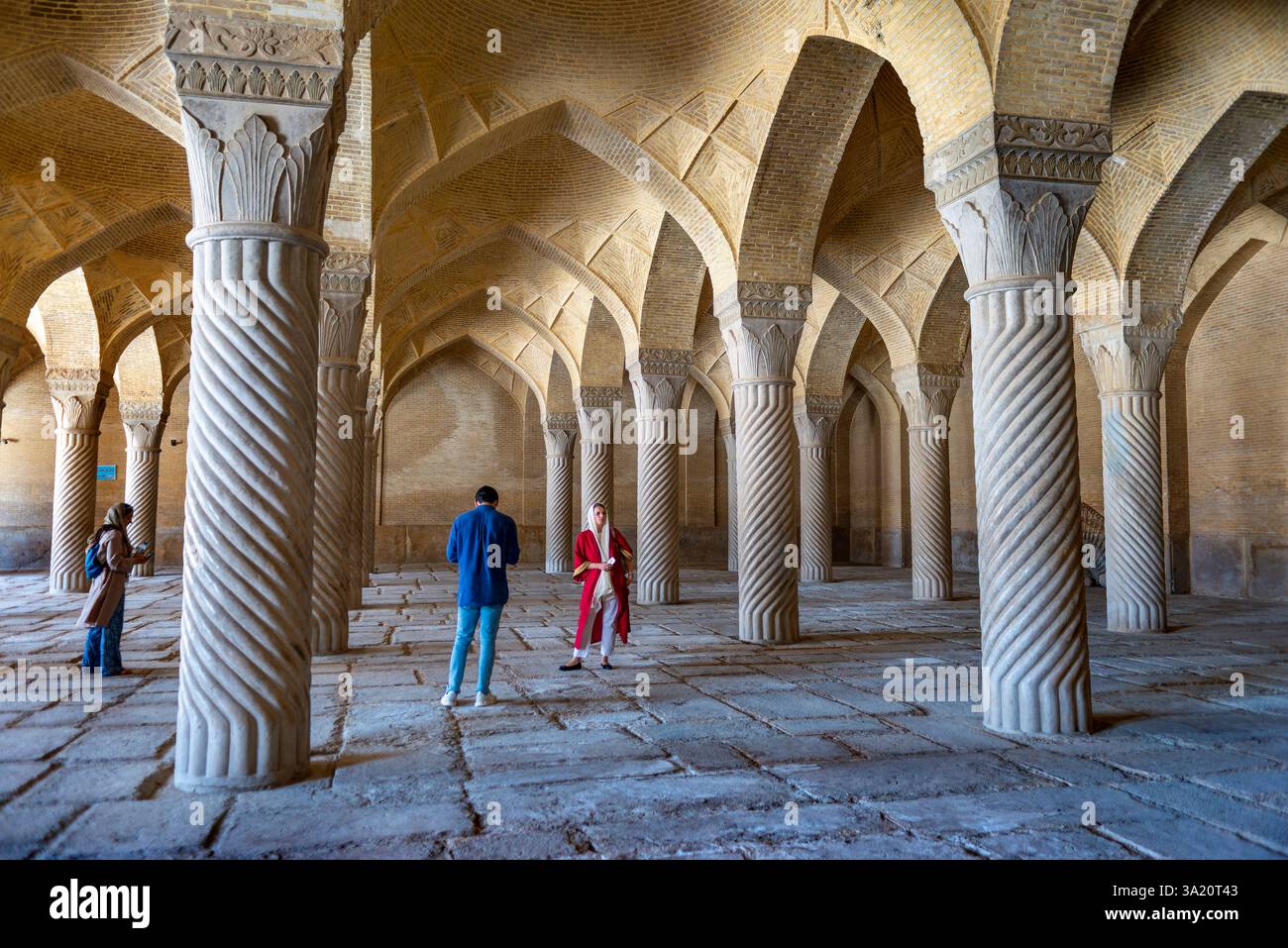 Vakil Mosque with an Iranian woman in red dress under its arches, in ...
